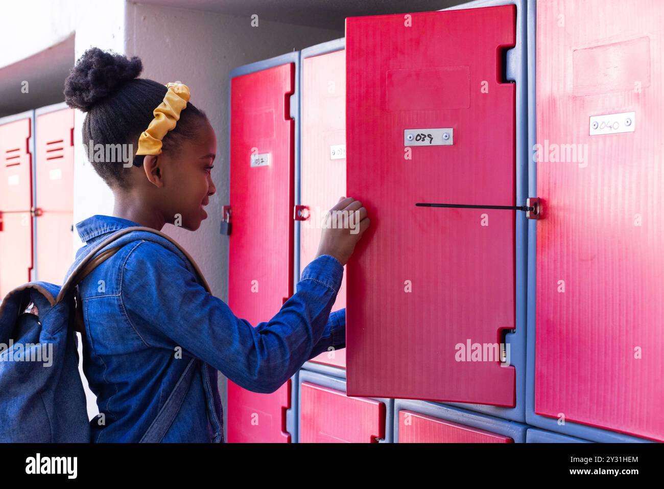 Opening locker, african american girl with backpack organizing school ...