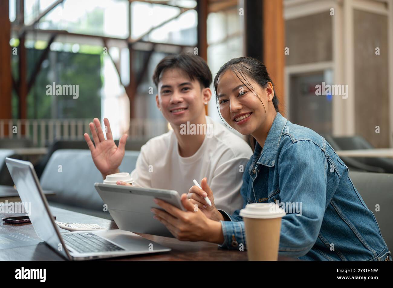 Two cheerful young Asian friends or colleagues, a male and a female ...