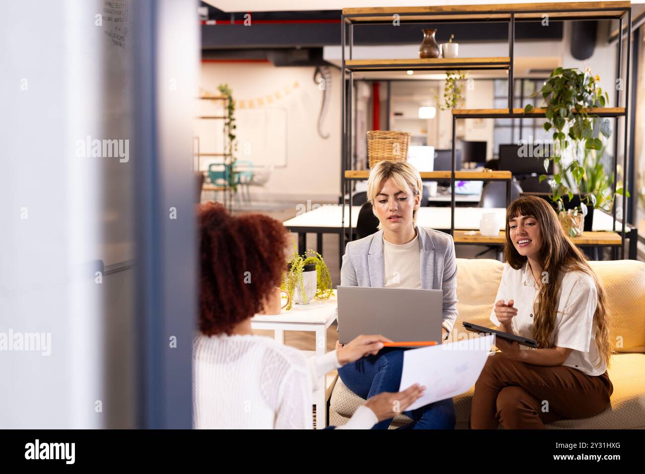 Using laptop and tablet for creative business, multiracial women ...