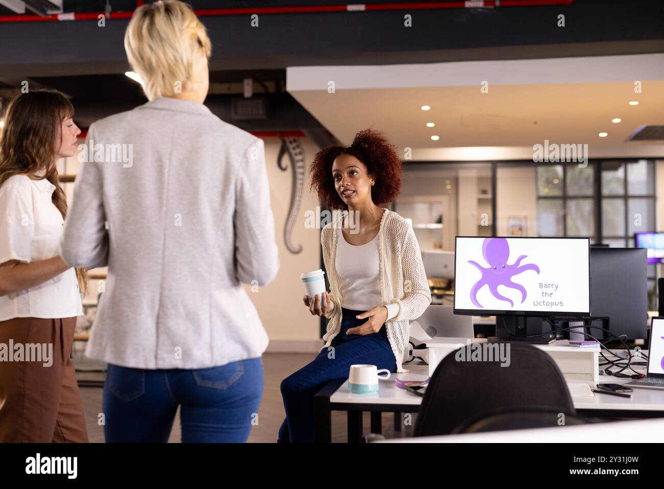 Collaborating in modern office, multiracial women discussing project ...