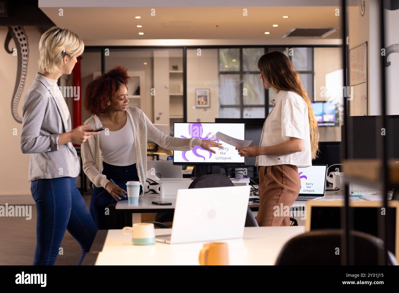 Discussing project ideas, three multiracial women collaborating in ...