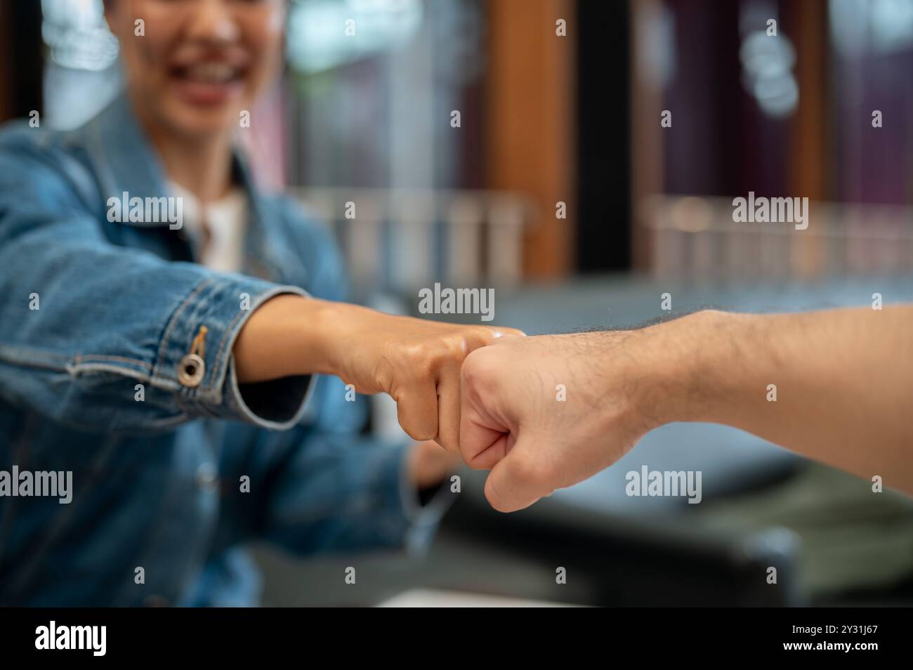 A close-up of two people giving each other a fist bump during a meeting ...