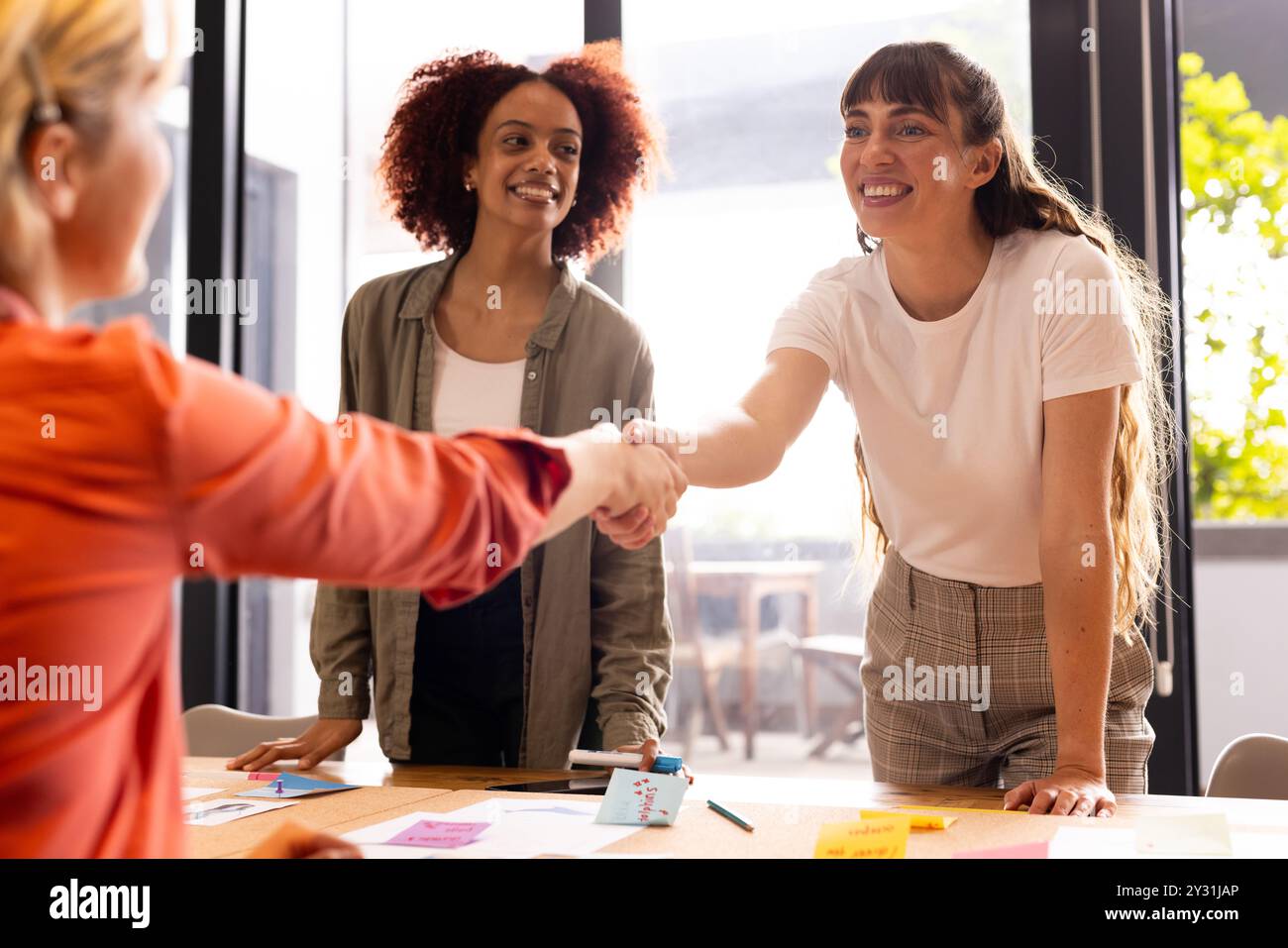 At office, Shaking hands, multiracial women in business meeting ...