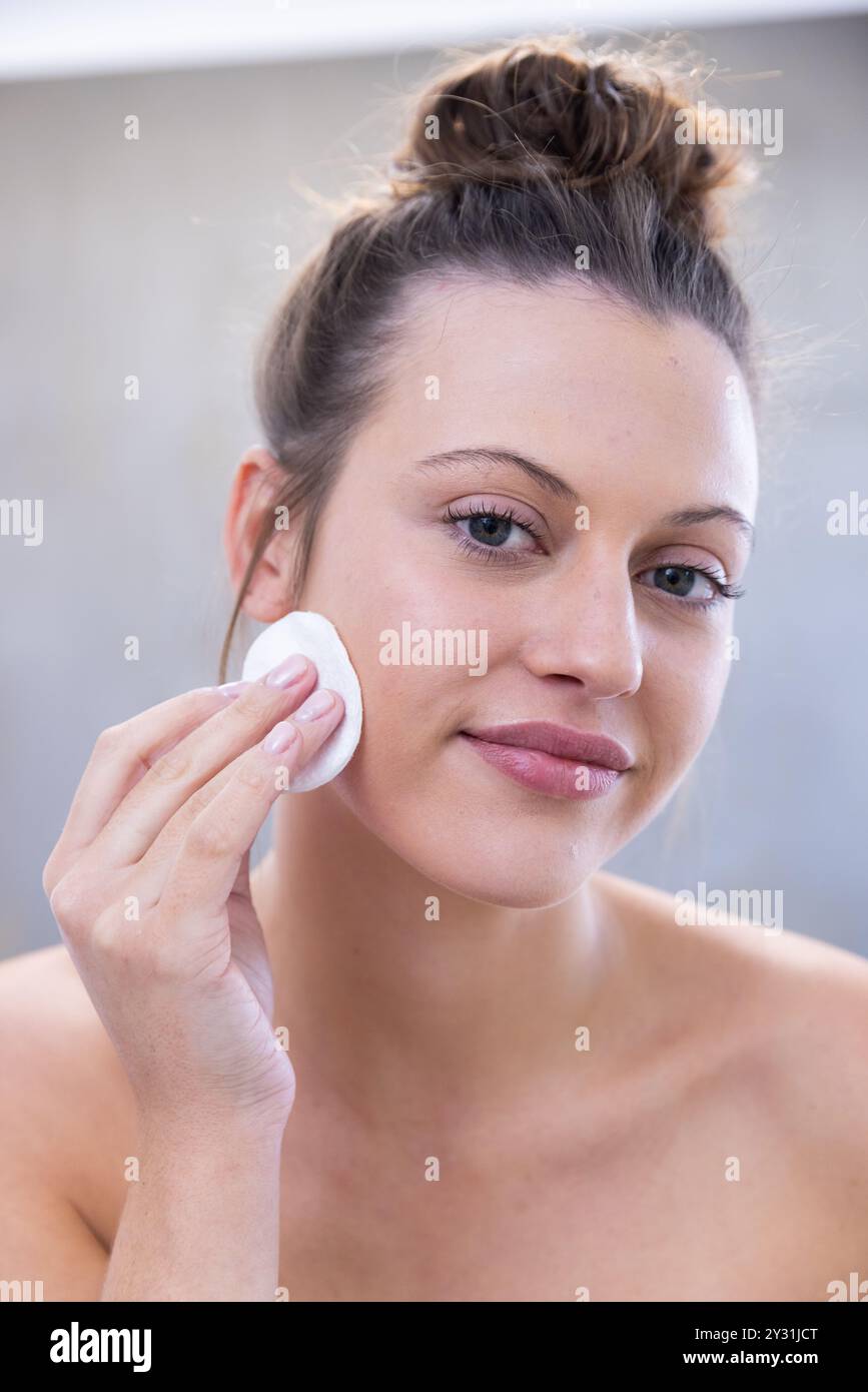 At home, Applying facial cleanser, young woman enjoying skincare ...