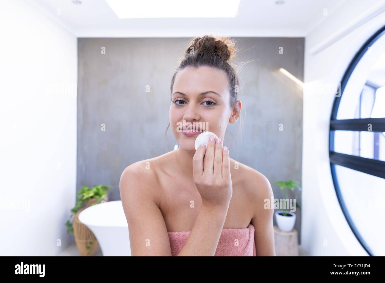 At home, Applying facial cleanser, young woman enjoying skincare ...