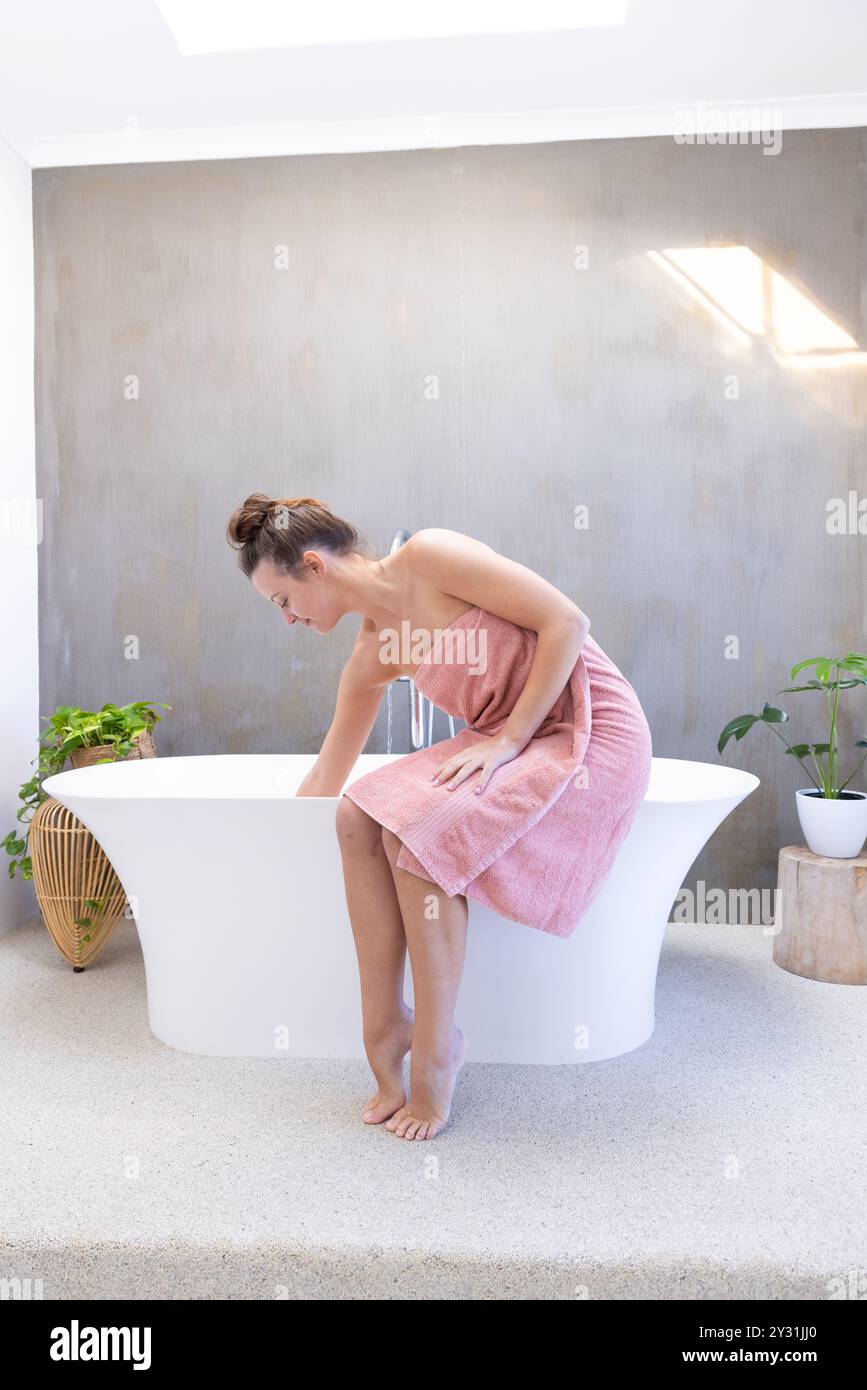 At home, Woman in towel preparing bath in modern spa, relaxing and ...
