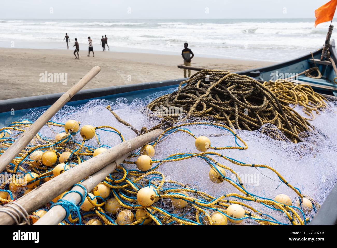 Group of rural villagers fisherman pulling fish net from the sea in Goa ...