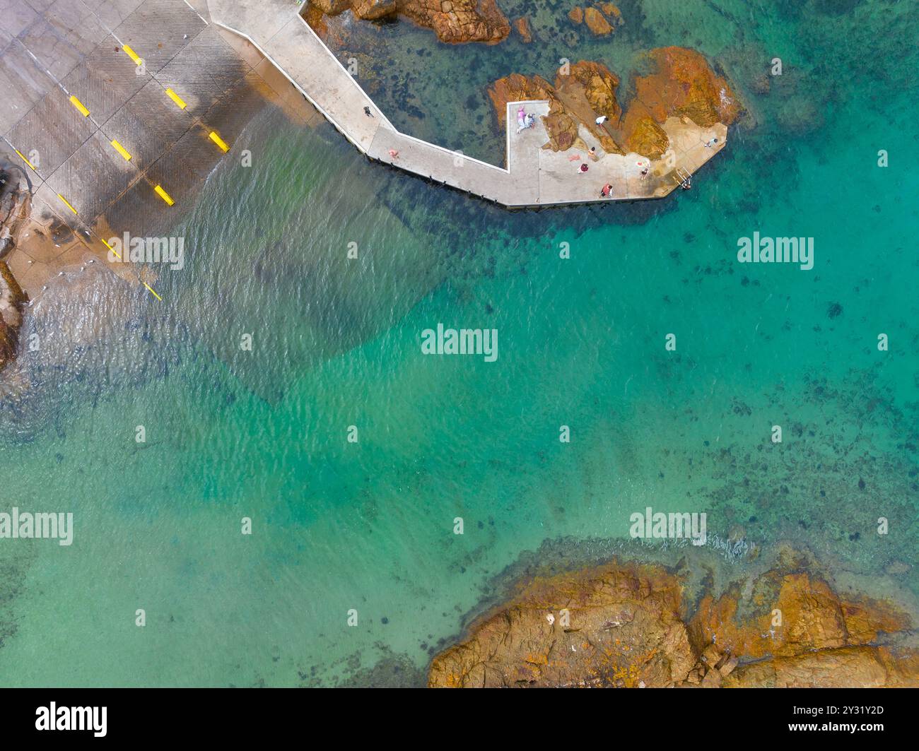 Aerial view of a coastal boat ramp and jetty in a calm coastal inlet at ...
