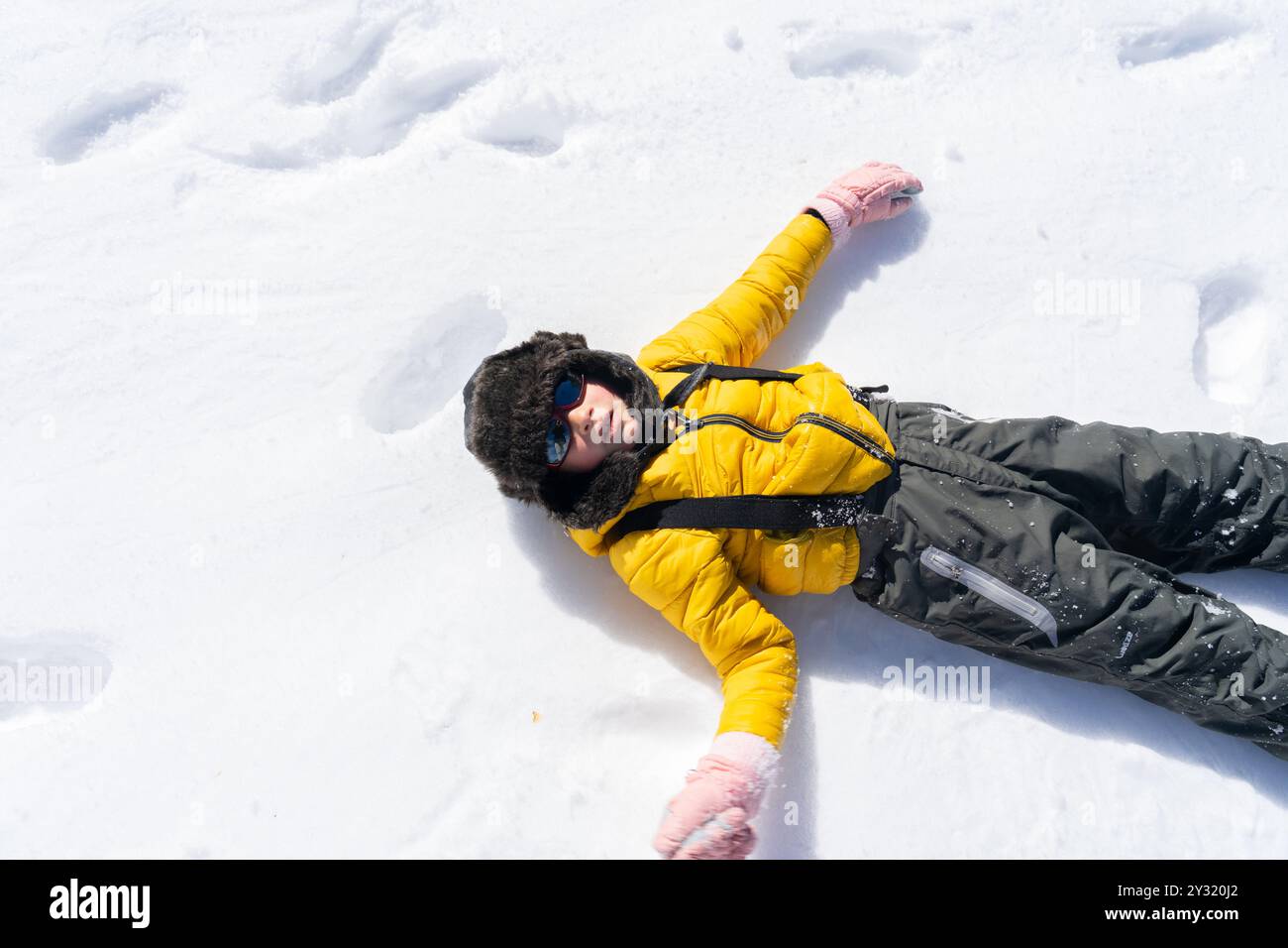 Boy lying face up in the snow Stock Photo - Alamy