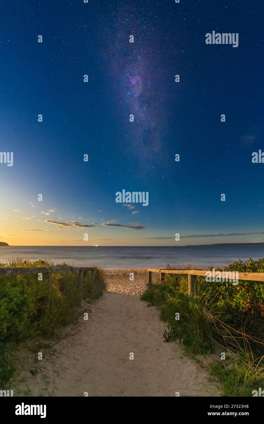 The Milky Way galaxy in the night sky over a coastal track leading to ...