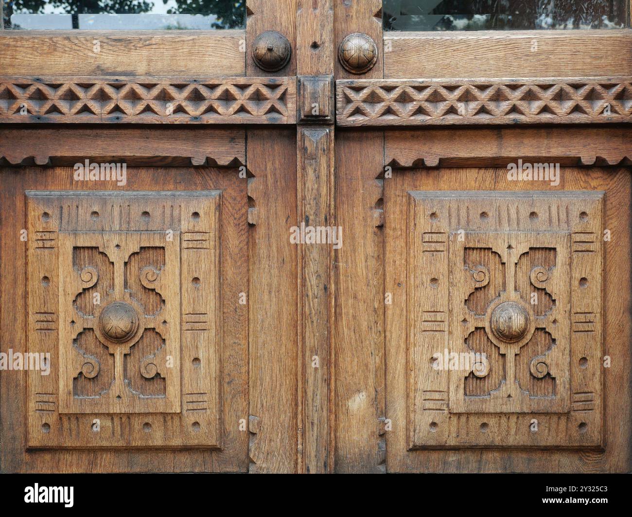 A detailed view of a highly ornate wooden door showcases intricate ...
