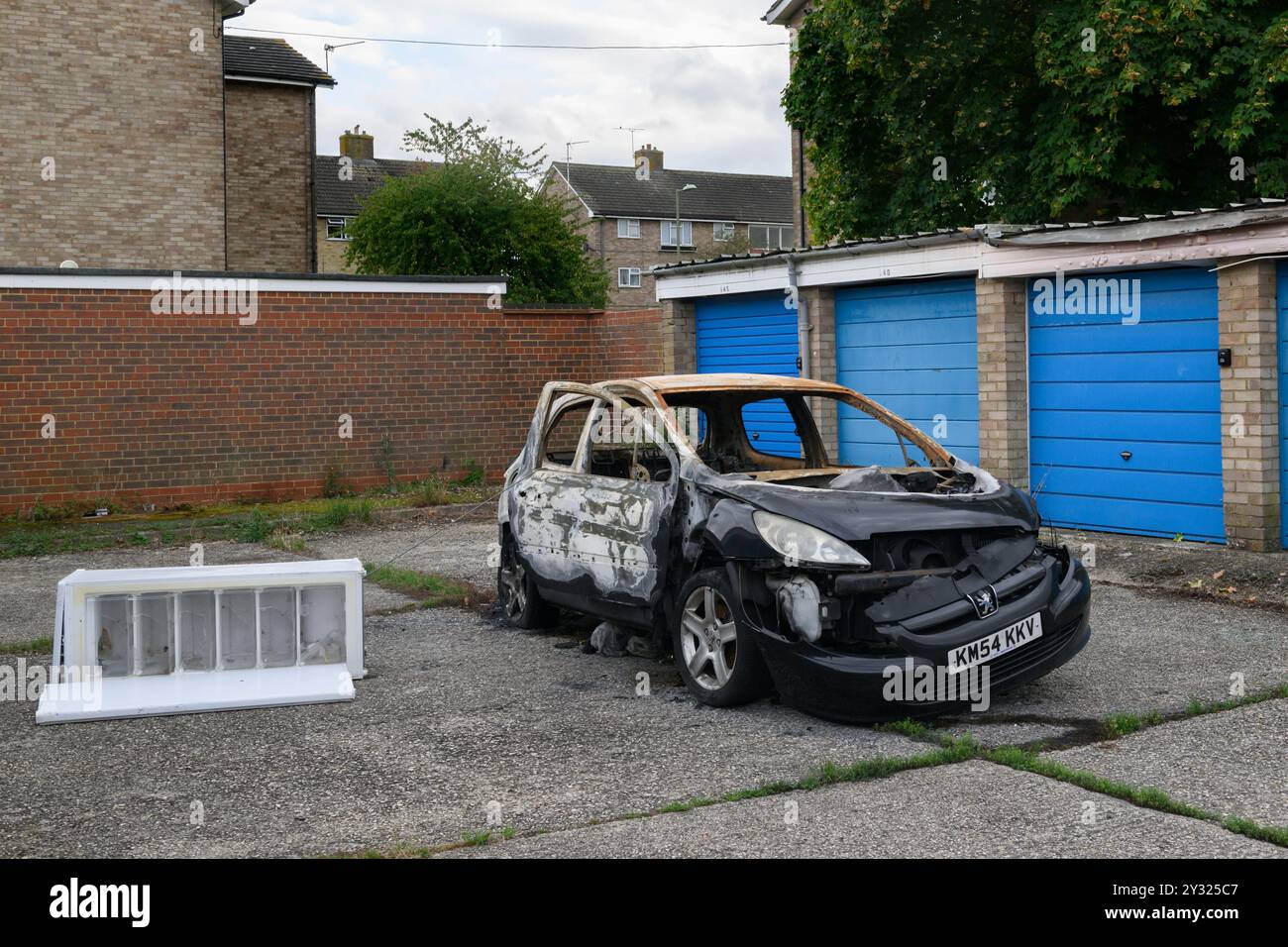 A burnt-out car left at a garage block off Saint Michael's Road ...