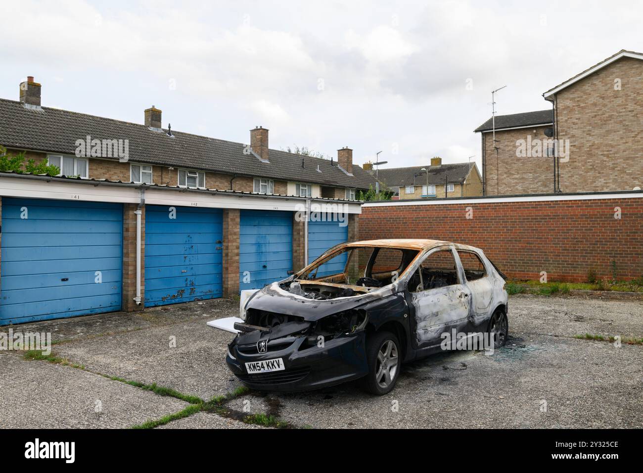A burnt-out car left at a garage block off Saint Michael's Road ...
