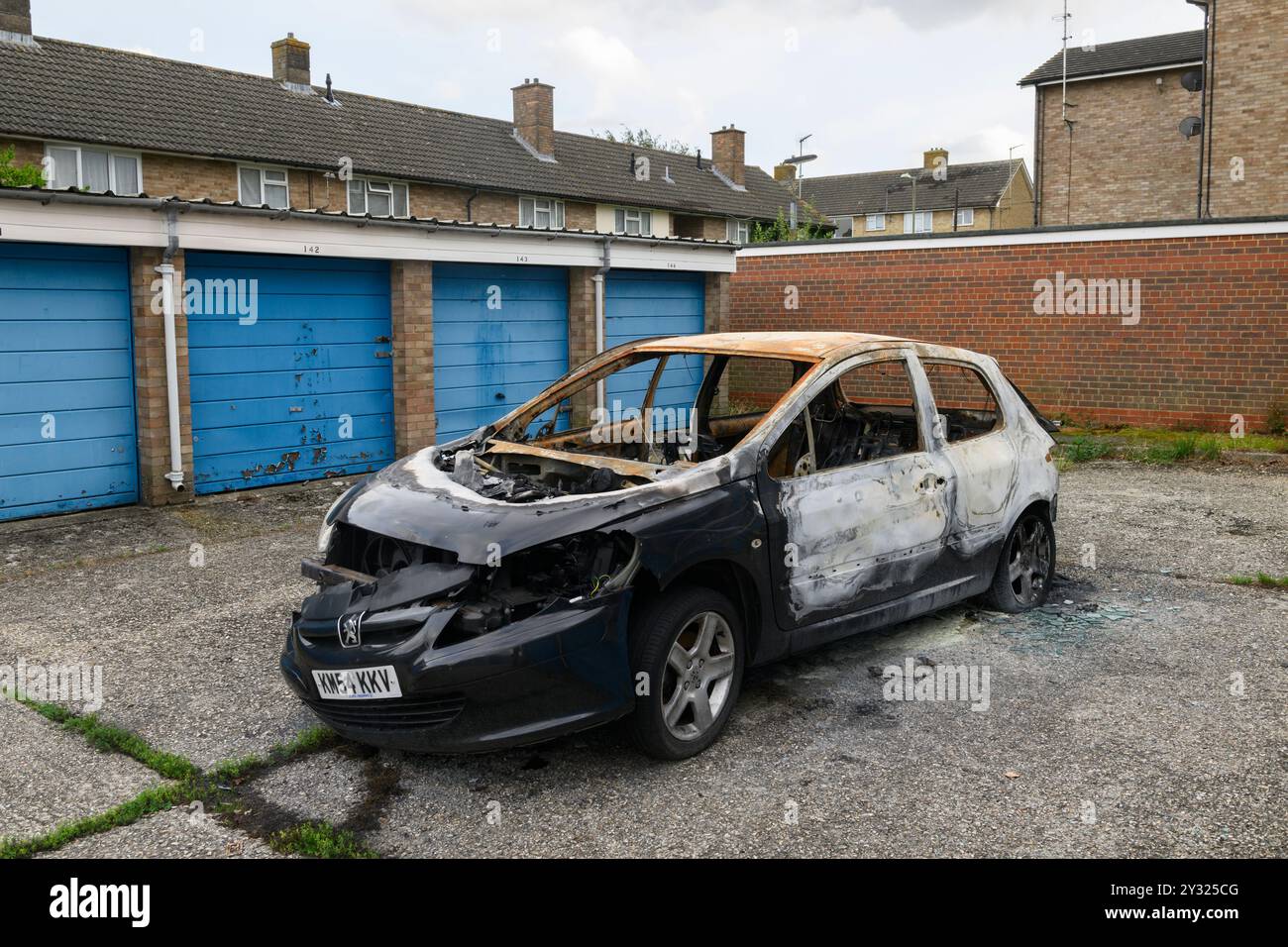 A burnt-out car left at a garage block off Saint Michael's Road ...