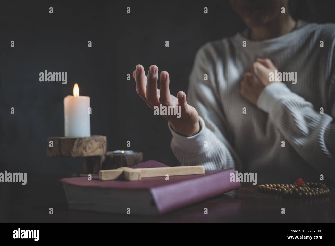 Woman praying while holding Bible and cross, Pray in the Morning ...