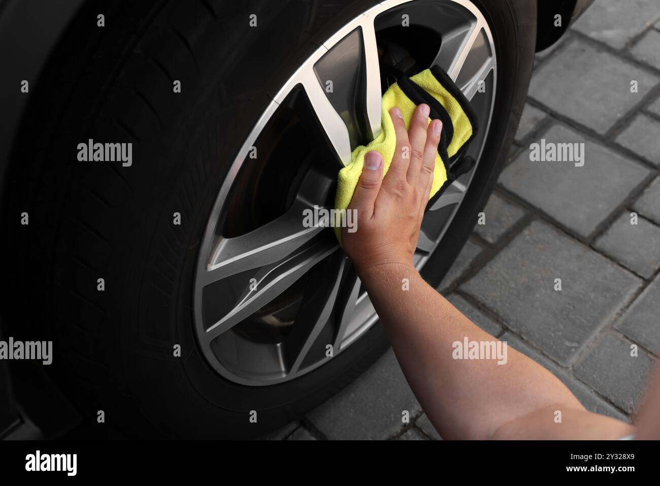 Man wiping car wheel with yellow rag, closeup Stock Photo - Alamy