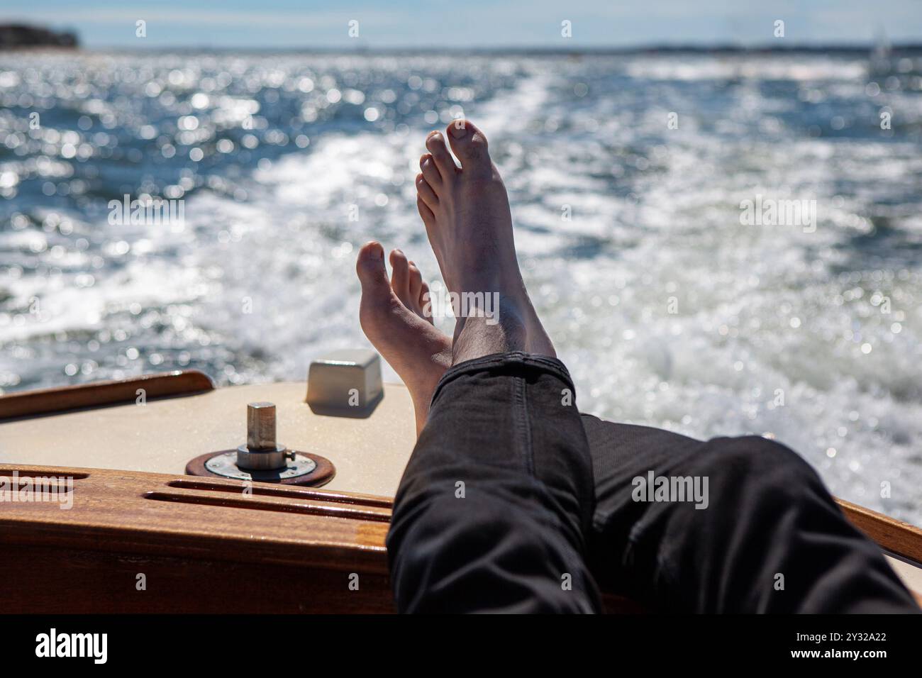Legs of a tourist during a boat ride Stock Photo - Alamy