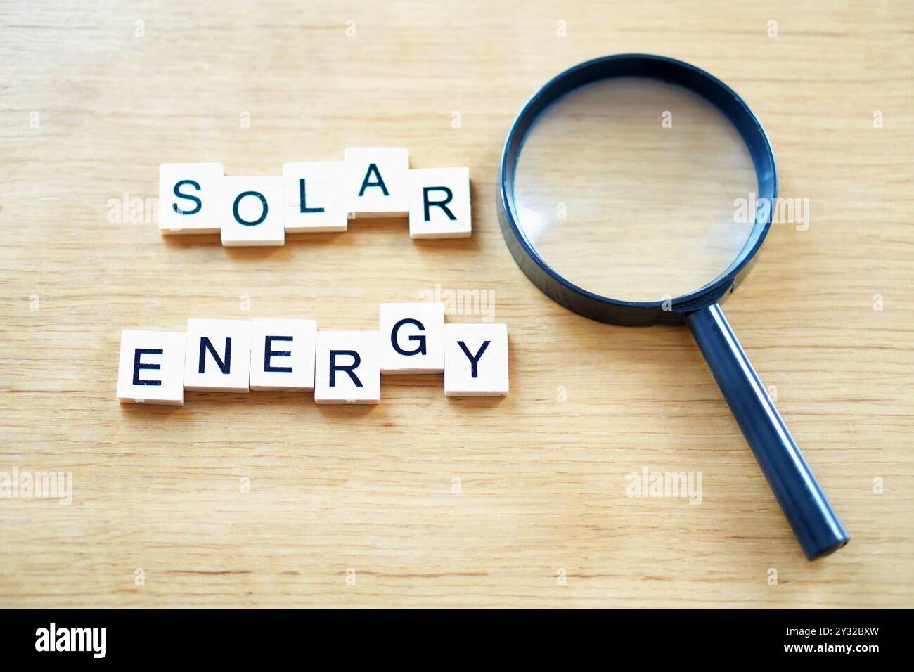 solar energy. wooden letters with magnifying glass Stock Photo - Alamy