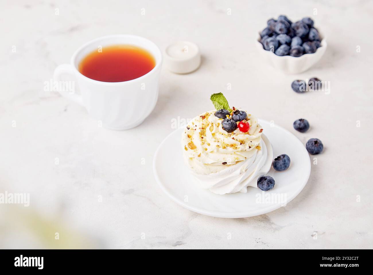 Traditional Pavlova Dessert with Tea Cup and blueberry. Autumn tea time ...