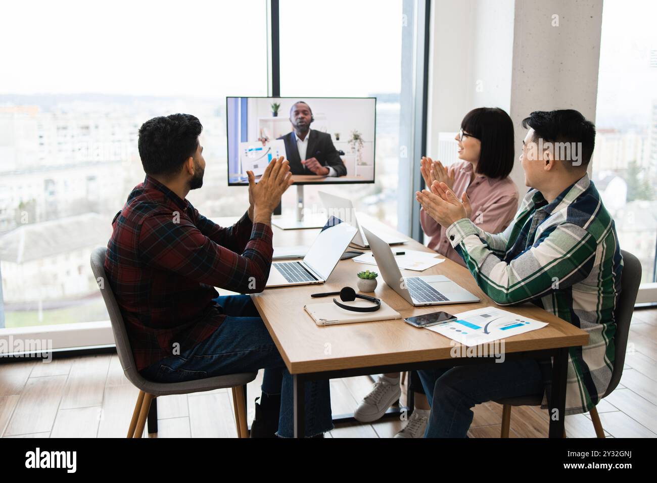 Team video conference meeting with applause in modern office Stock ...