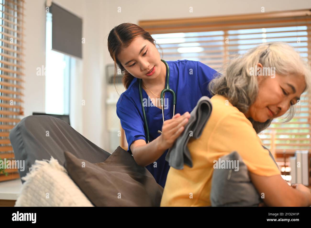 Physical therapist doing back percussion on a senior patient to help ...