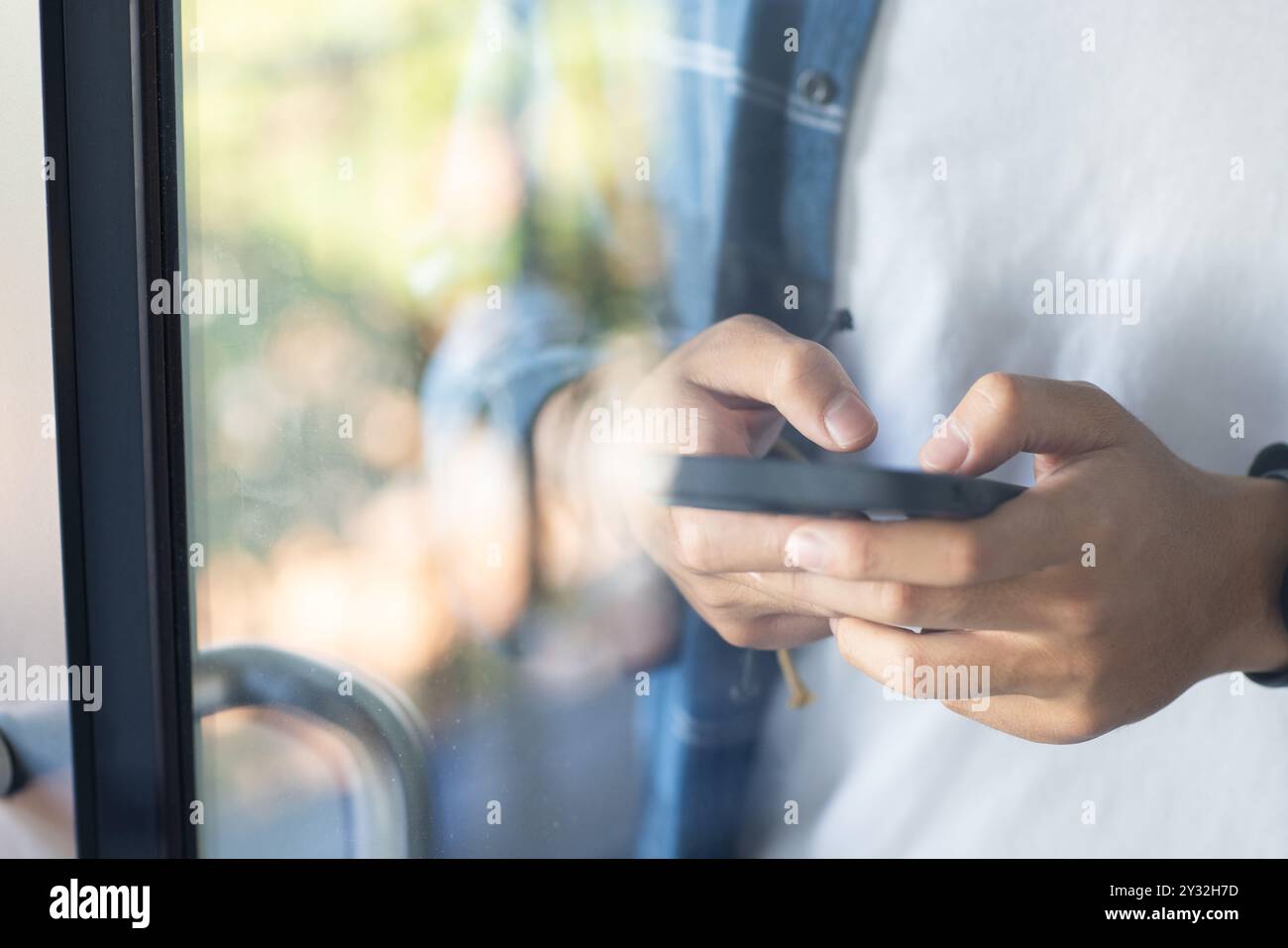 At school, using smartphone, asian teenage boy texting while standing ...