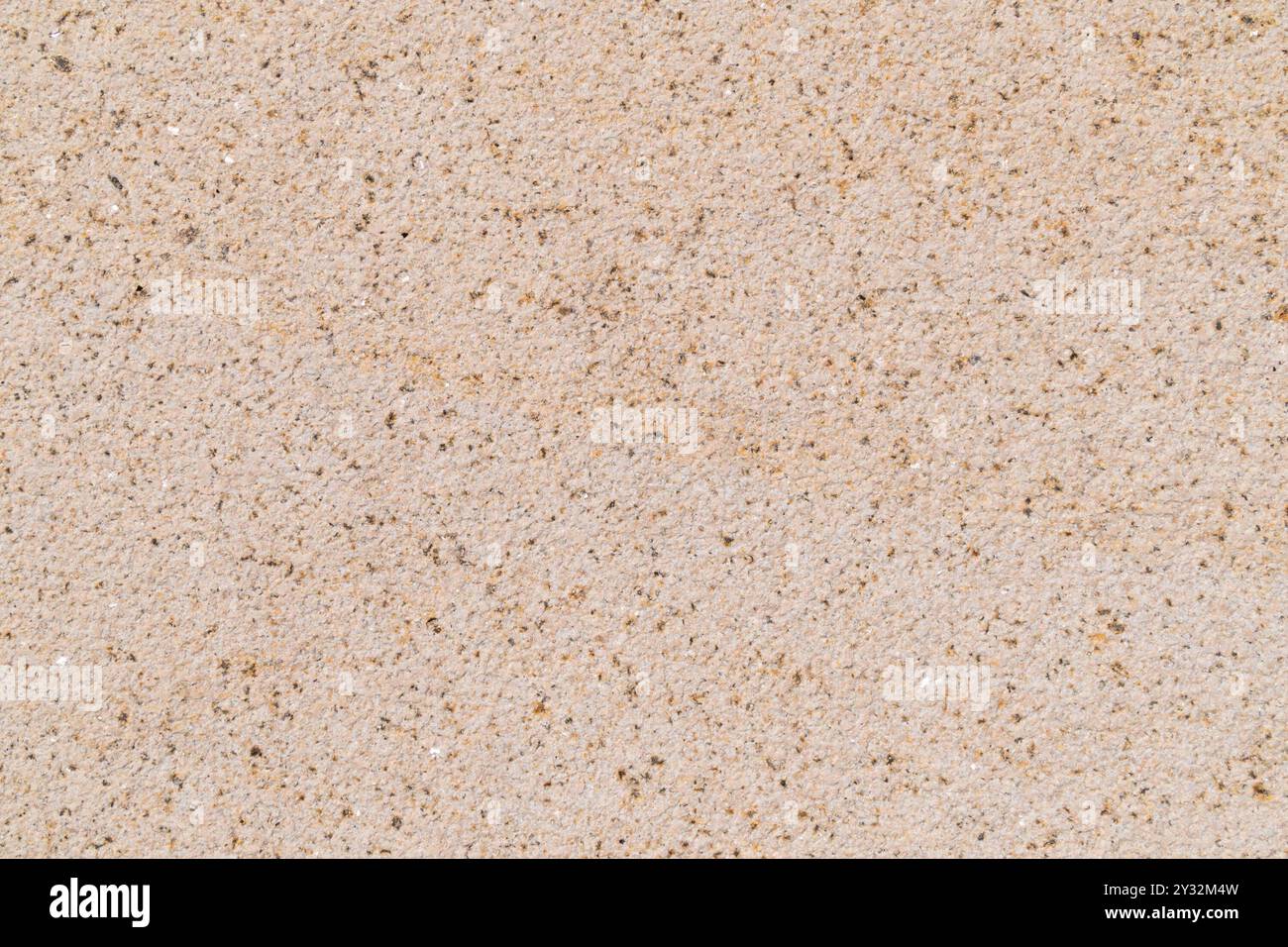 Close-up of textured beige stone surface with fine grains and speckled ...