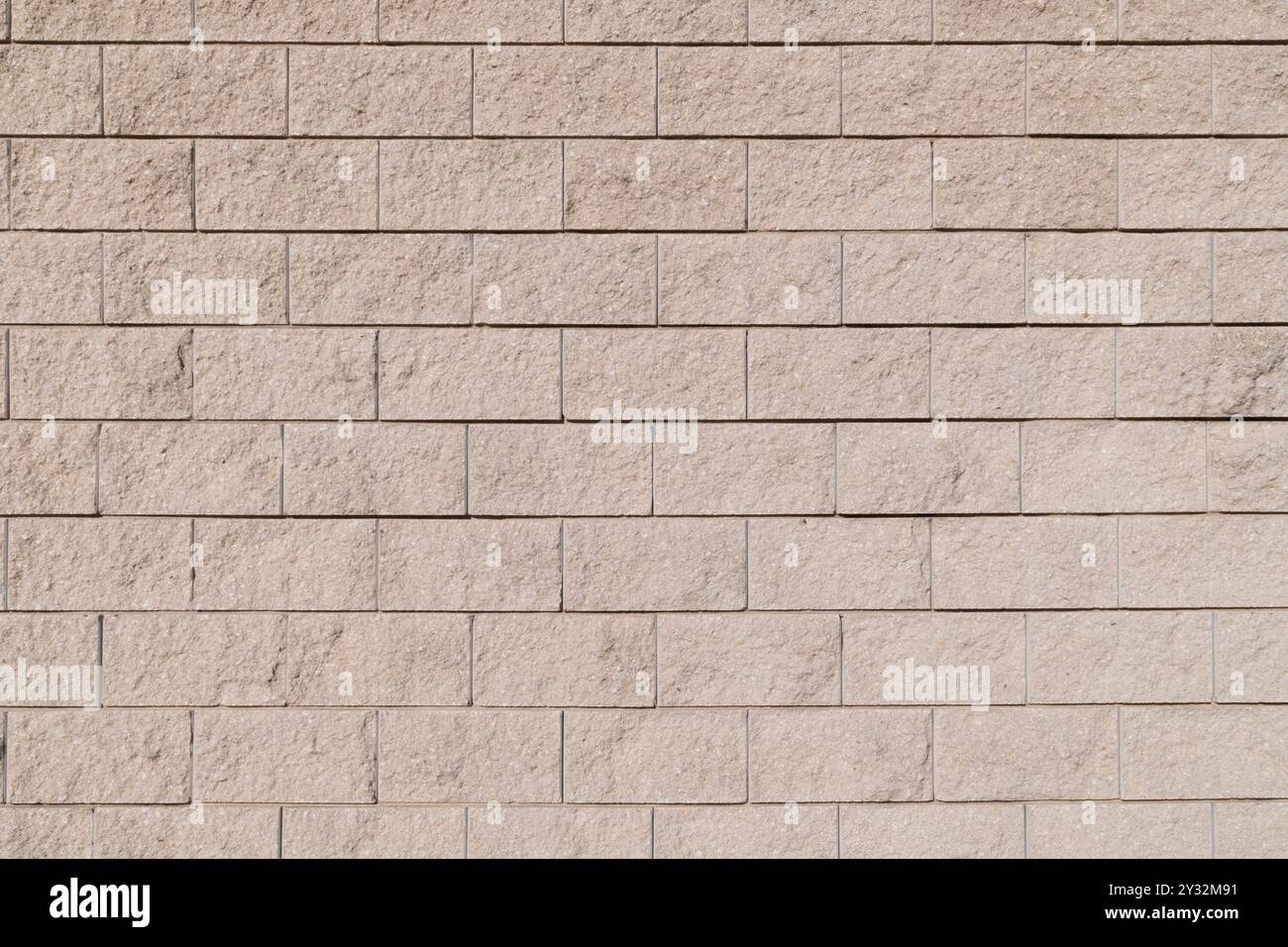 Close-up of a textured stone wall with uniform rectangular blocks ...