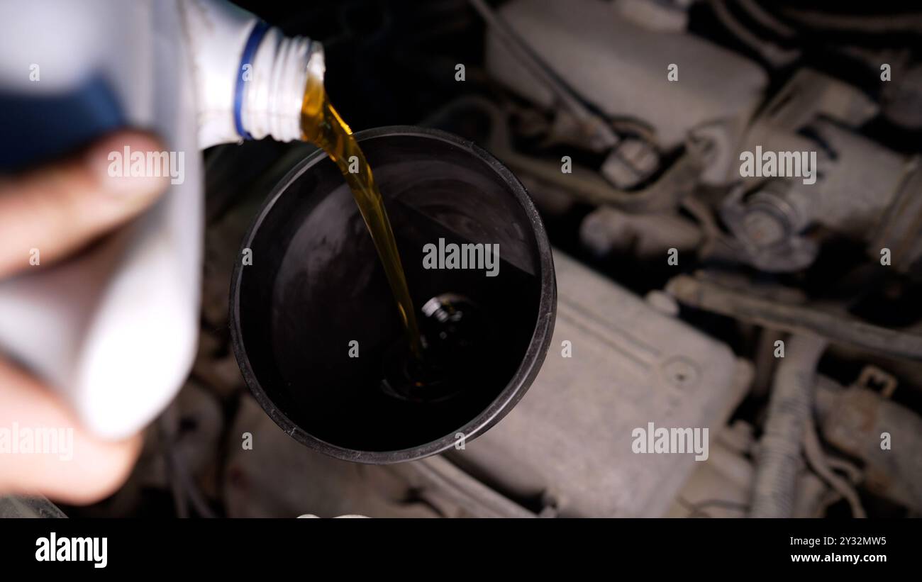The process of pouring engine oil into a car in a car service. Close-up ...