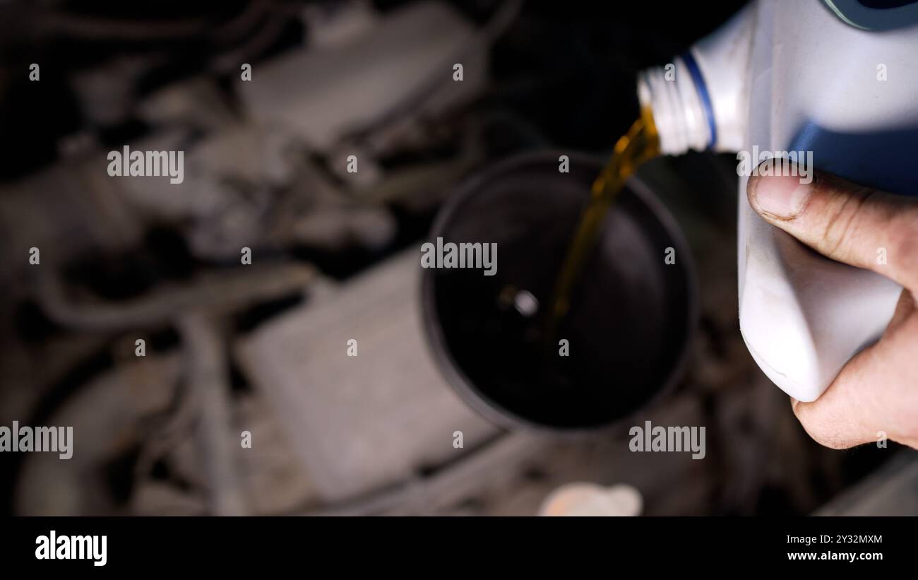A worker checks the oil level in the car. Worker checks the engine oil ...