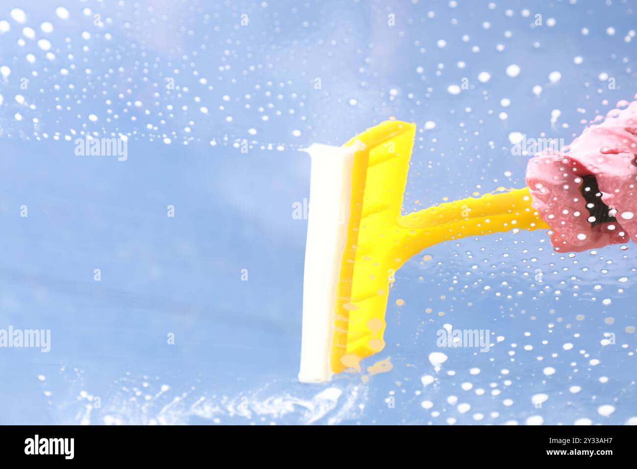 Woman washing window with squeegee tool against blue sky, closeup Stock ...
