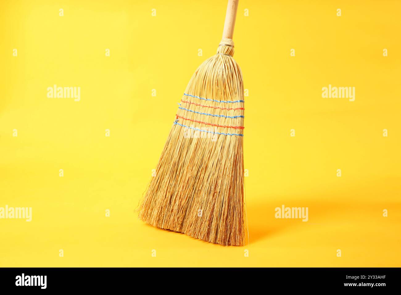 One corn straw broom on yellow background Stock Photo - Alamy