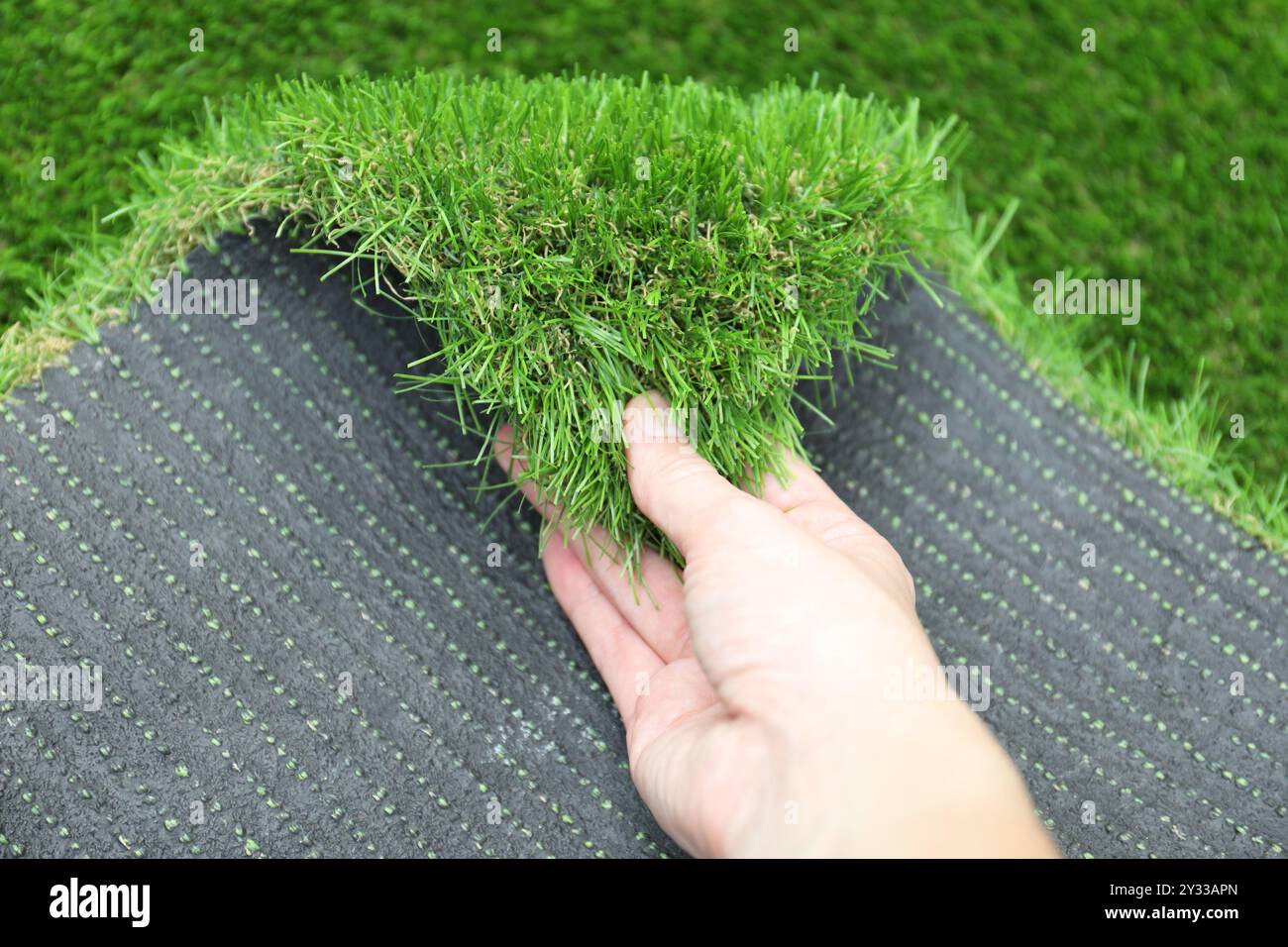 Woman with sheet of artificial turf, closeup Stock Photo - Alamy