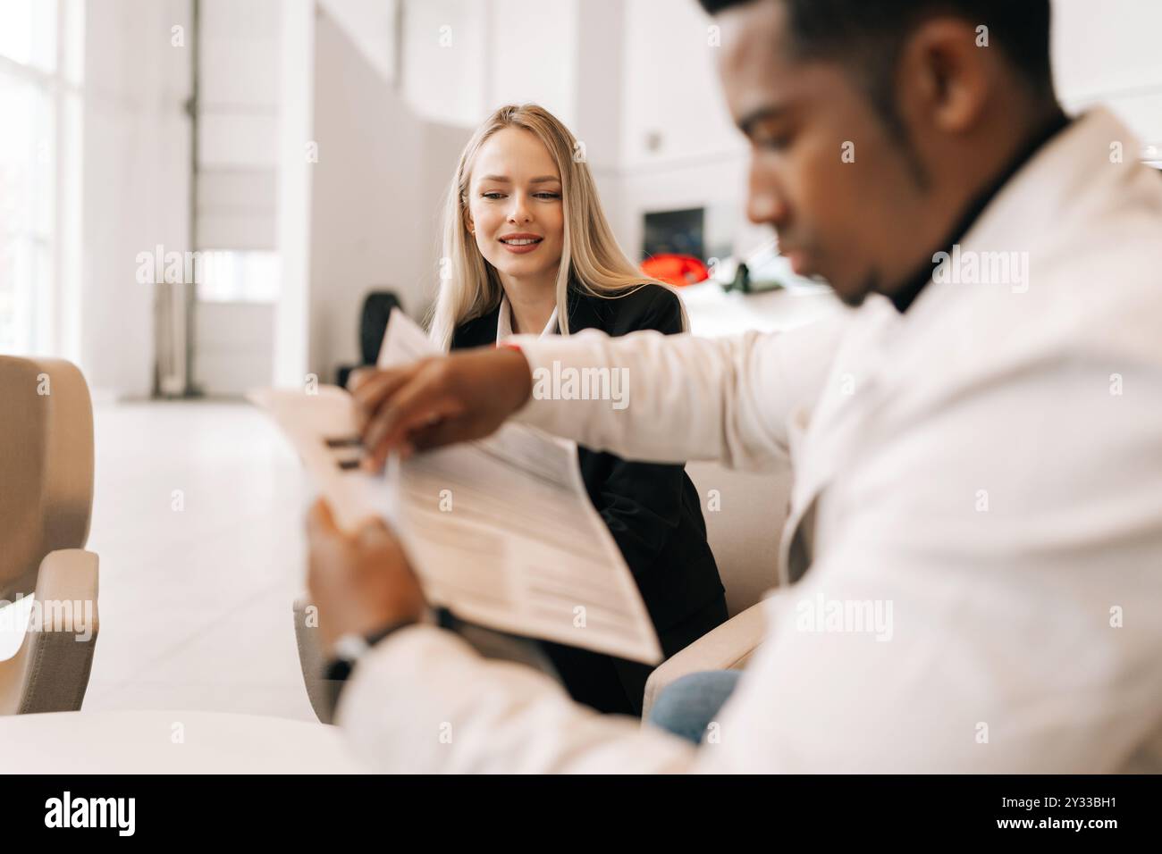 Mediums shot of pensive African-American male customer reading car ...