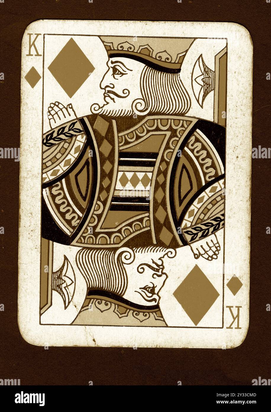 A vintage king of diamonds playing card in sepia on a black background ...