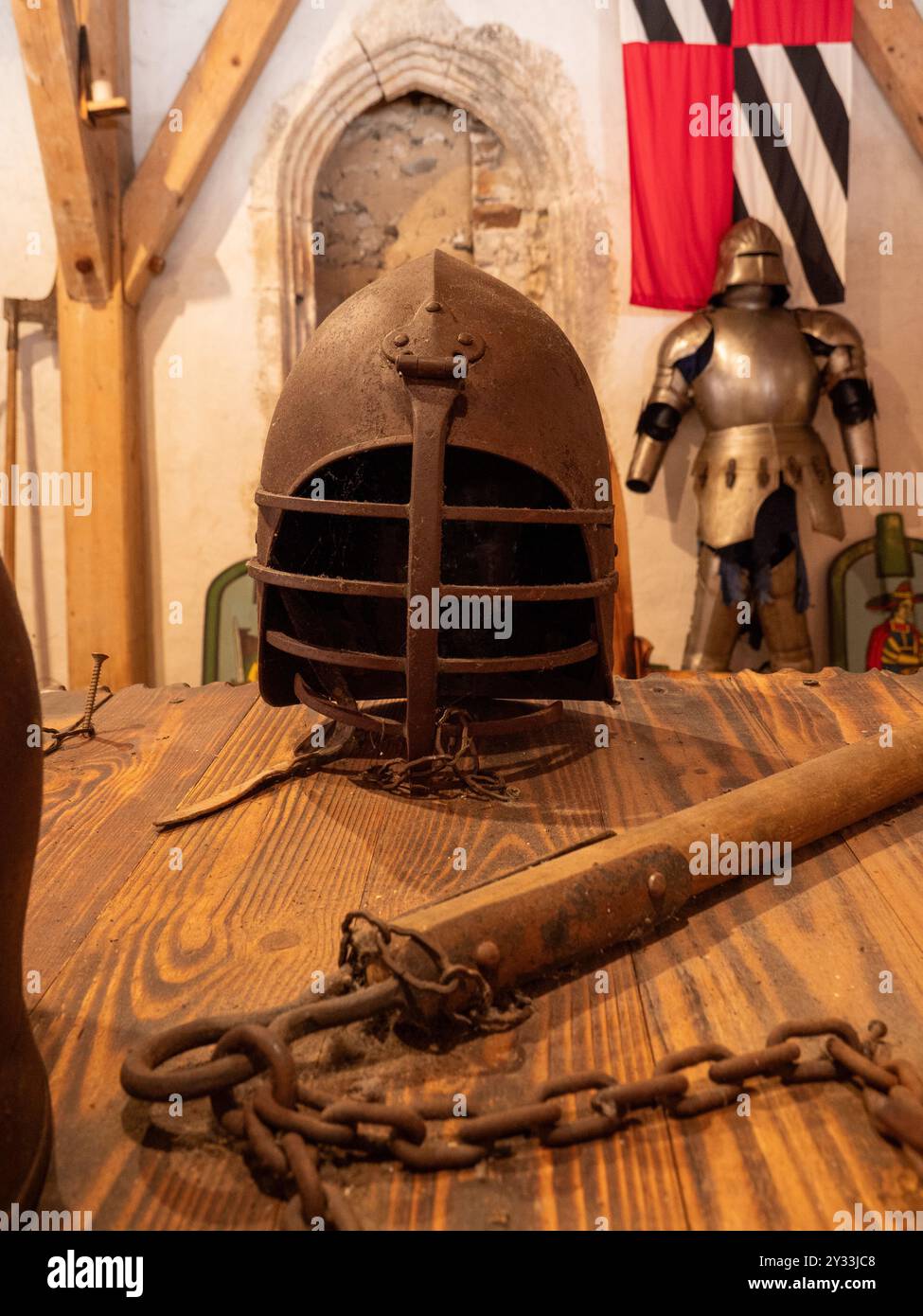 Medieval knight helmet and weapon on a wooden table with armor and ...