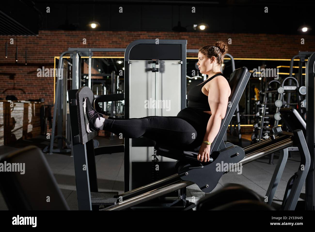 A confident young woman in active wear engages in leg workouts ...