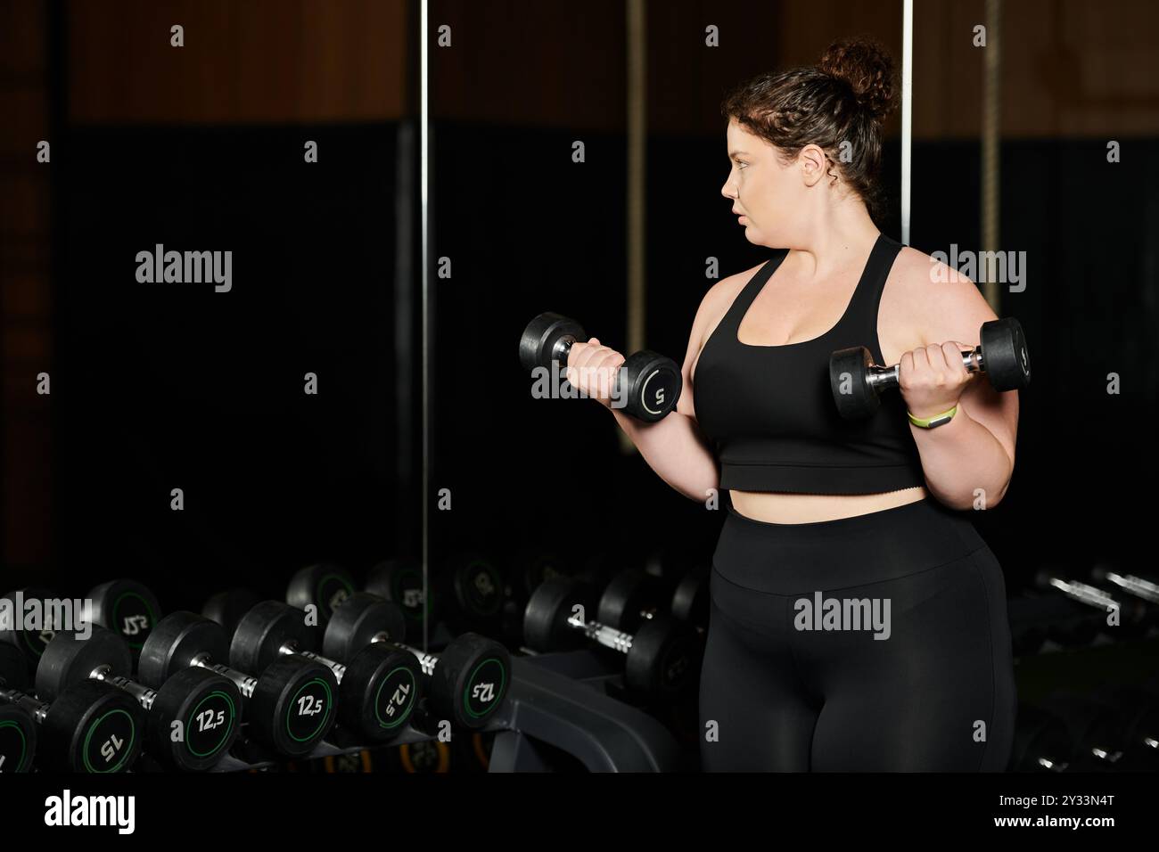 A plus-size woman lifts weights, showcasing strength and confidence in ...