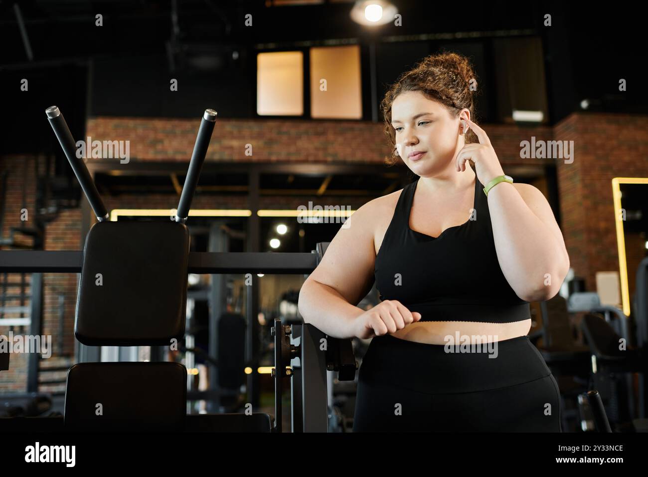 A young plus-size woman engages in her workout routine, embracing body positivity at the gym ...