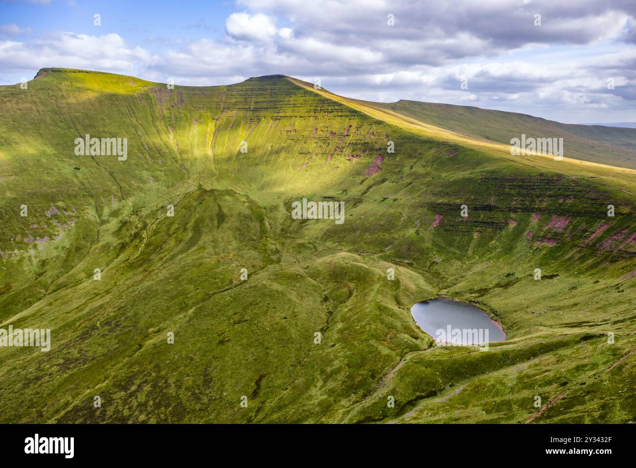 Aerial view of a small glacial lake beneath twin mountain peaks on a ...
