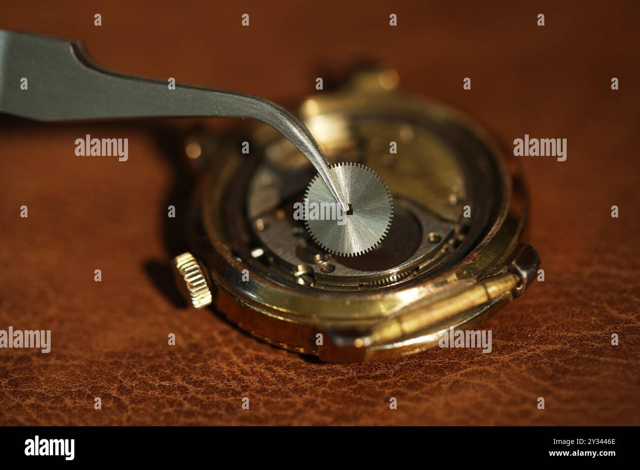 Mechanism of vintage wrist watch and tool on leather surface, closeup ...