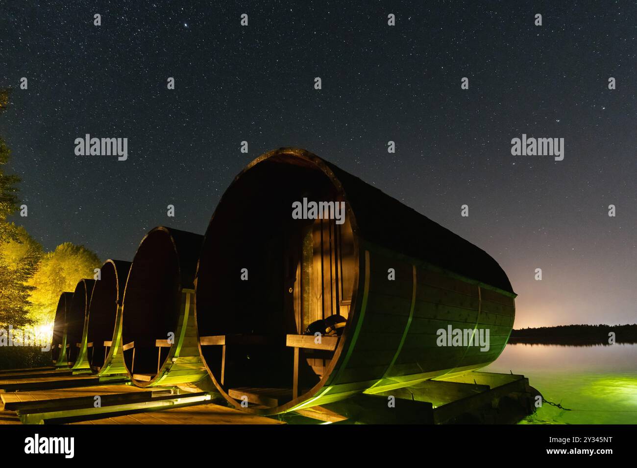 Night photo, starry sky, barrels of a house on the water on Lake Rummu ...