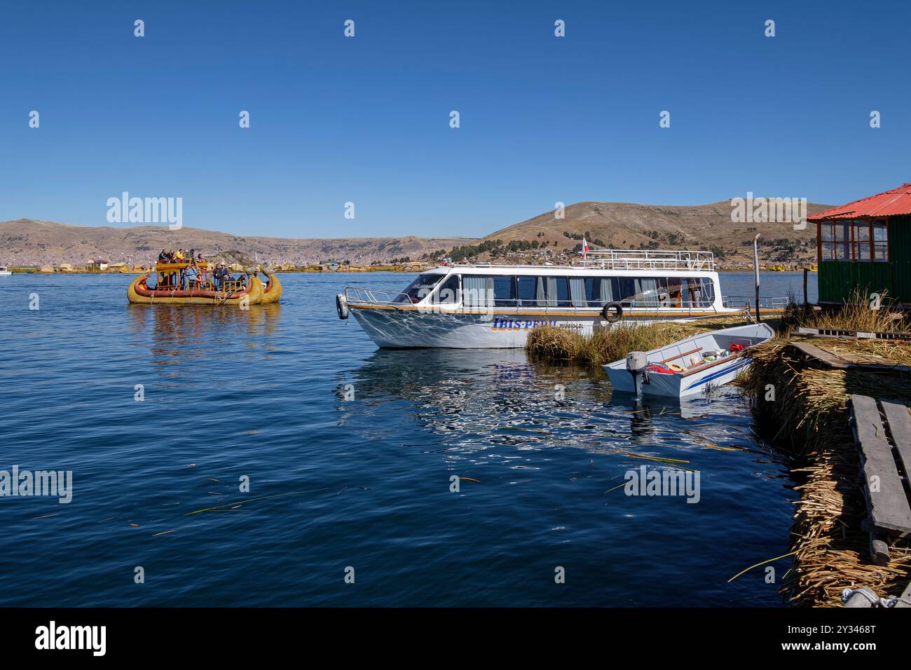 A leisure boat moored at a jetty on one of the Uros floating reed ...