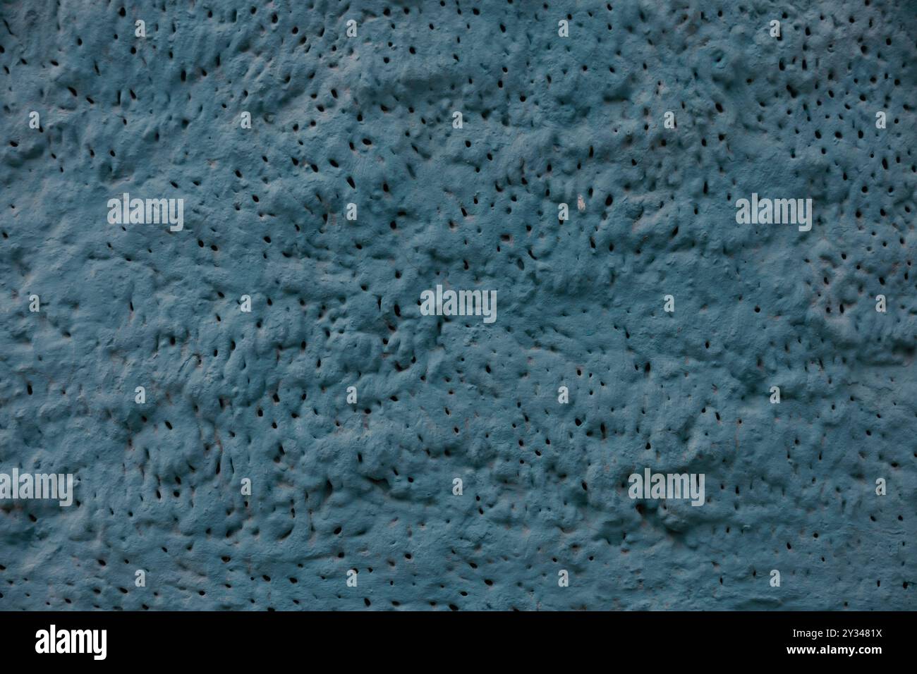 A textured wall with rough plaster creating an uneven, porous surface ...