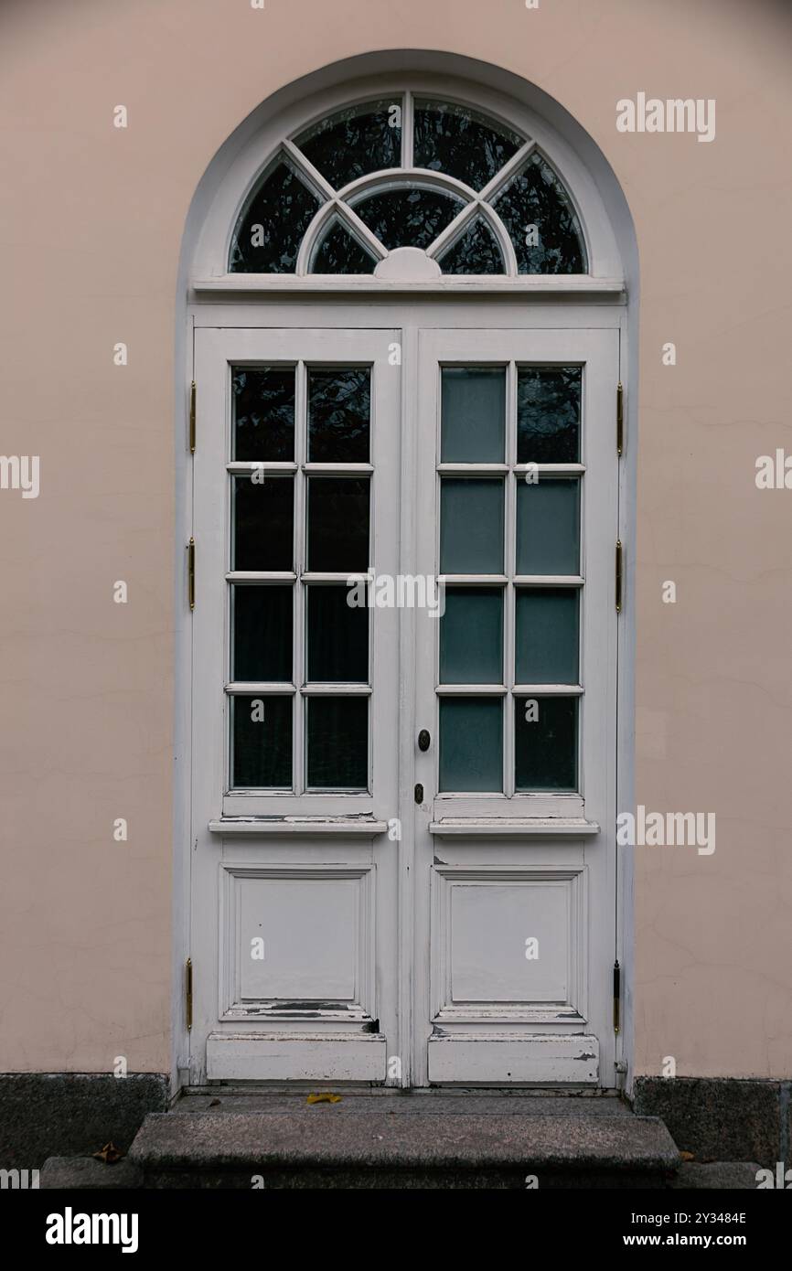 A tall arched wooden door with a vintage design, featuring multiple ...