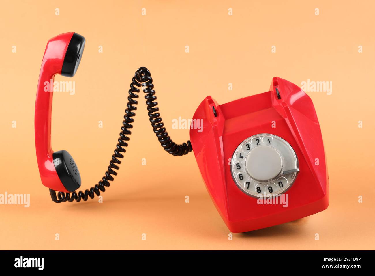One red telephone with handset on pale orange background Stock Photo ...