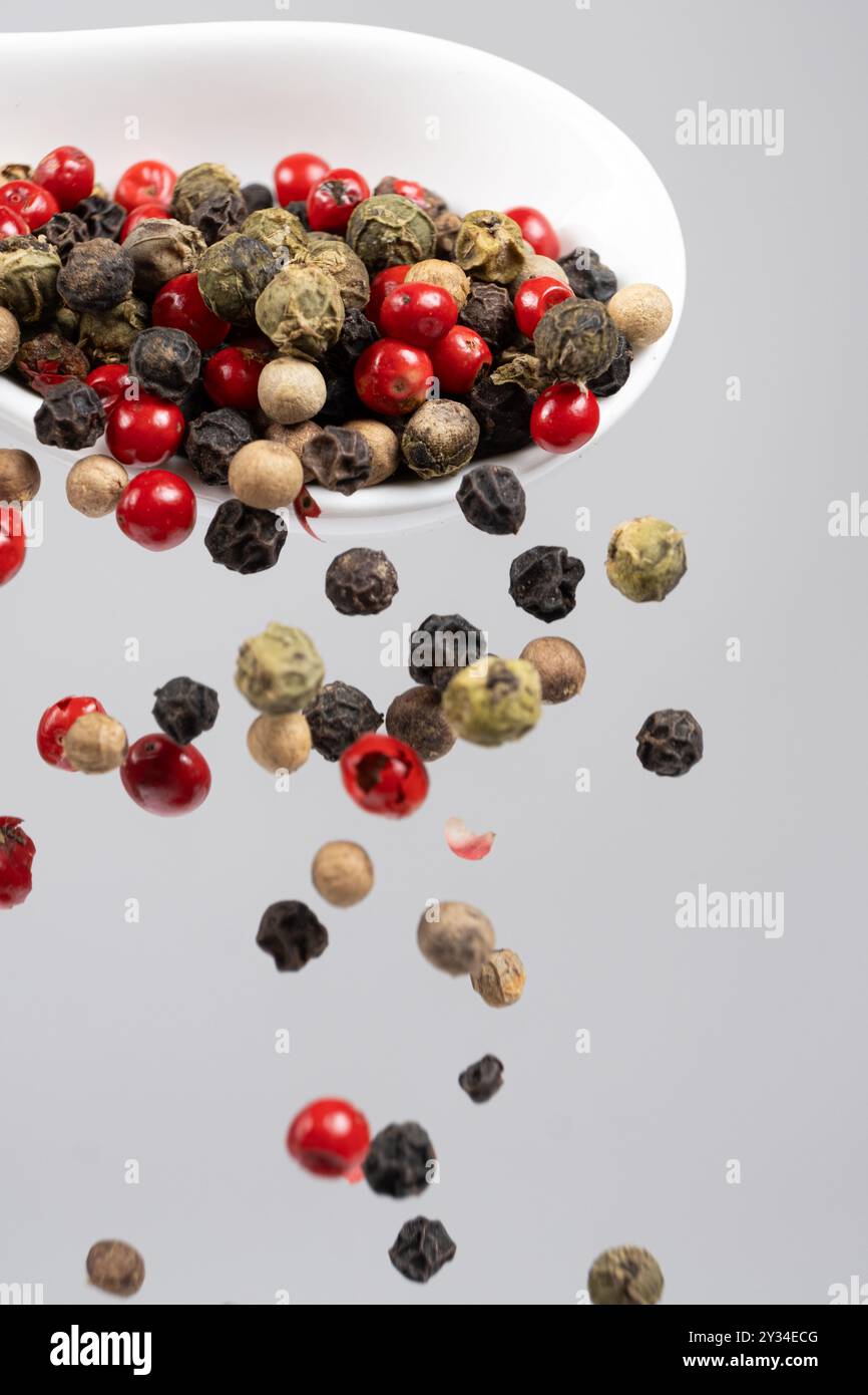 Different types of peppercorns pouring. Red, green, white and black ...