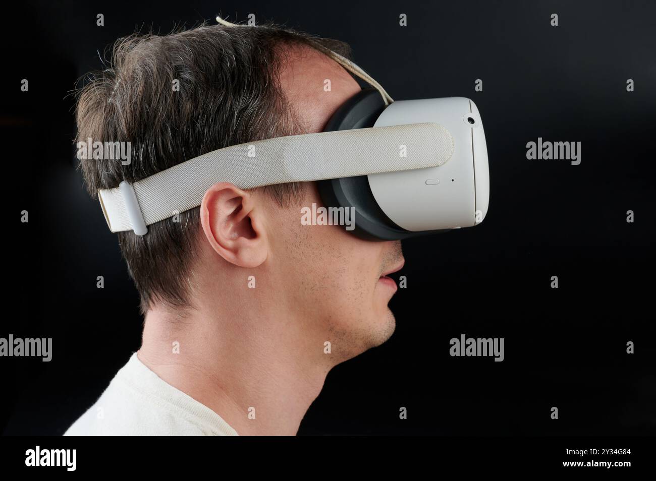 Man watching content in Virtual reality goggles side view isolated ...