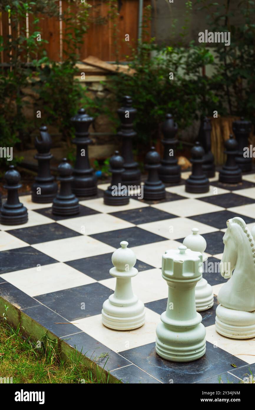 An expansive chess board featuring oversized chess pieces placed upon ...