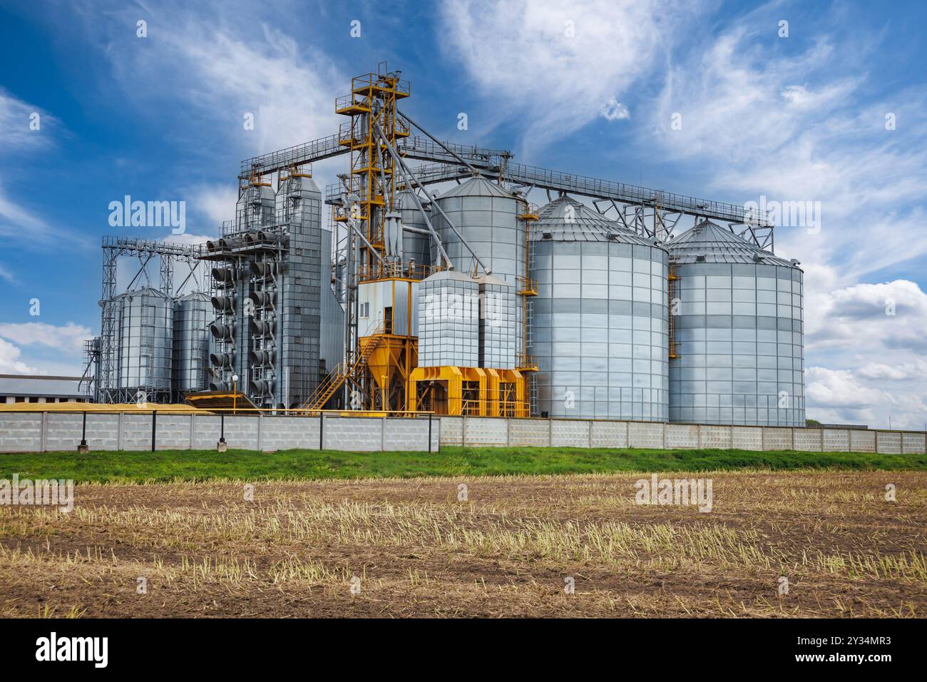 large grain elevator with multiple cylindrical metal silos, structural ...